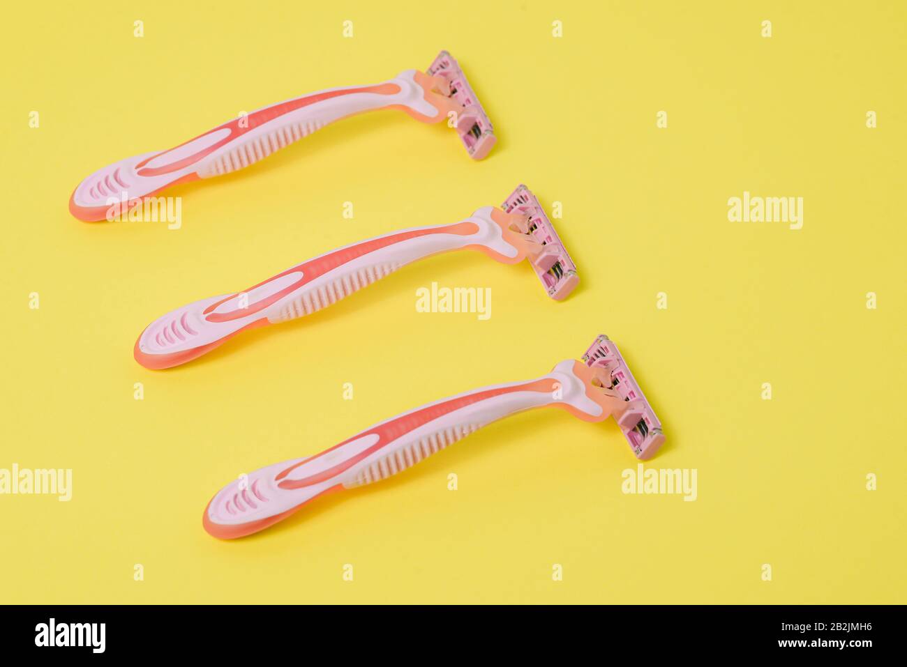 Hair depilation. Pink razors on a colored background. Hair removal from ...