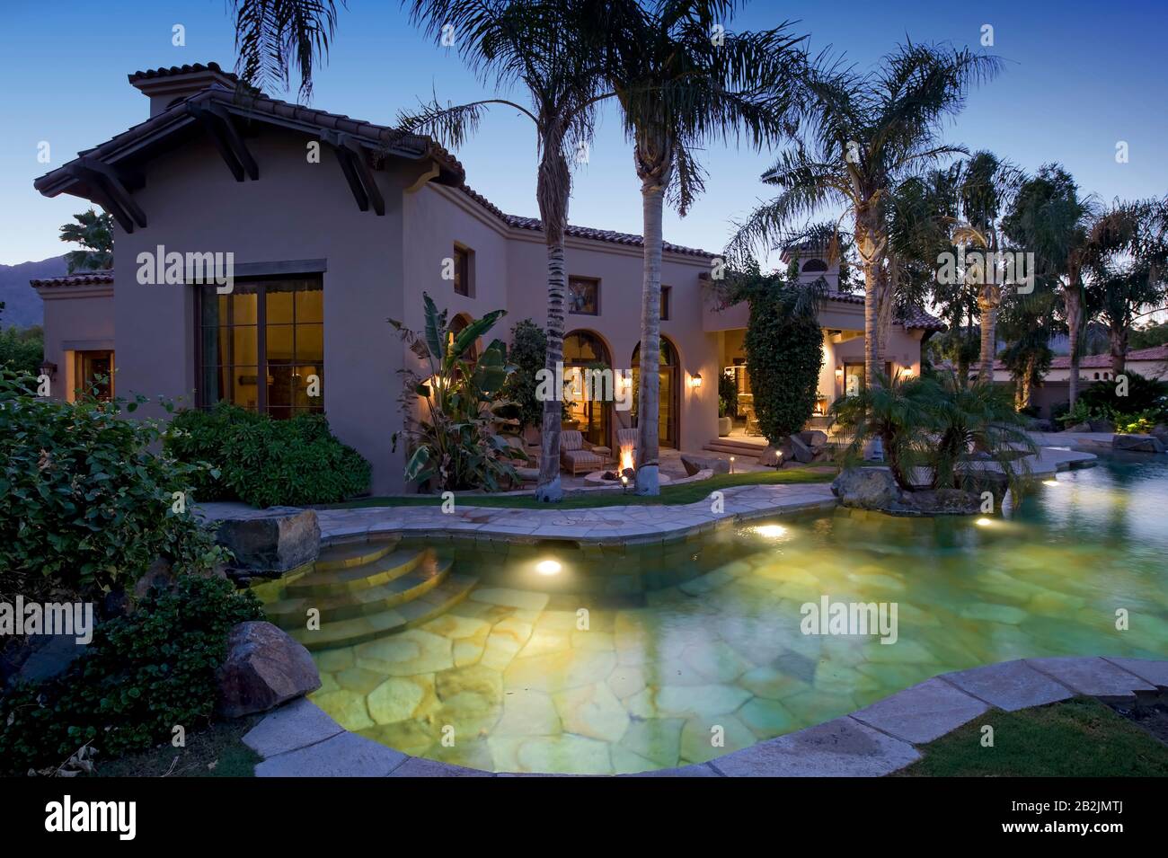 Swimming pool in foreground of luxury mansion Stock Photo - Alamy