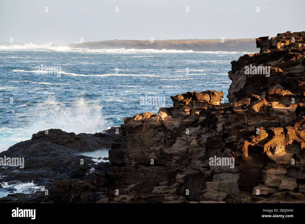 waves crashing on rocky volcanic shoreline of Lanzarote at faro point ...