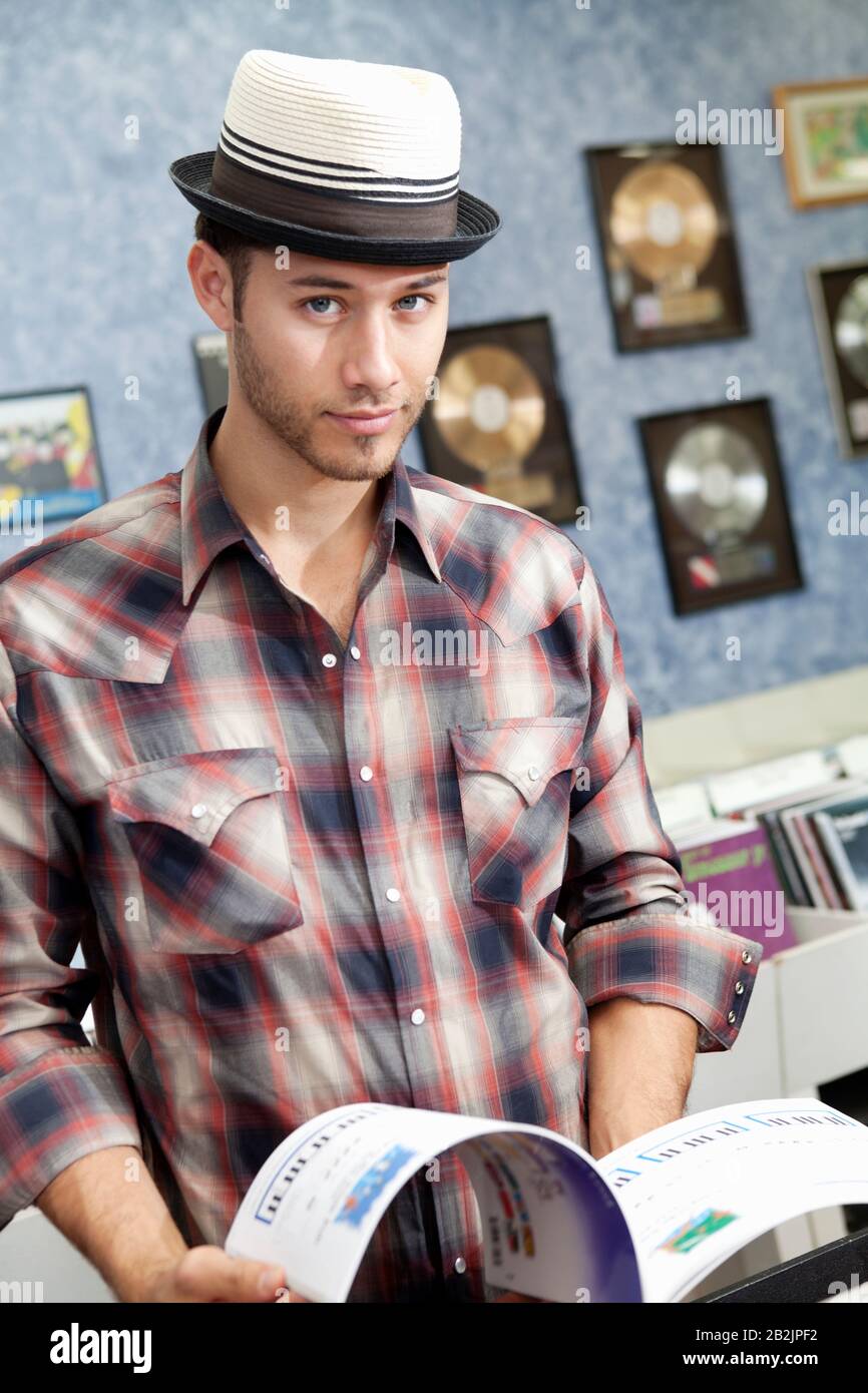 Portrait of a confident music store owner with book Stock Photo - Alamy