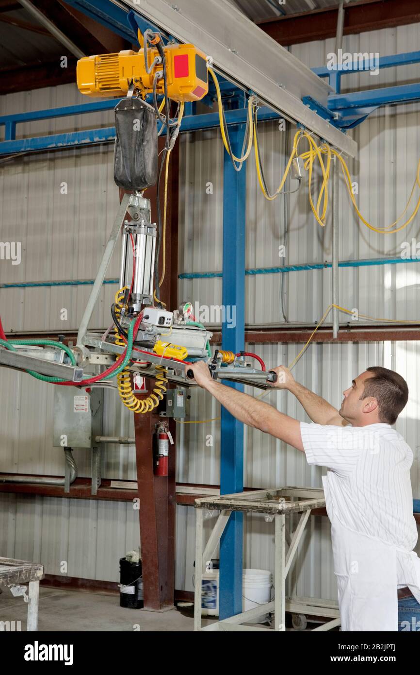 Industrial worker adjusting machinery in factory Stock Photo - Alamy