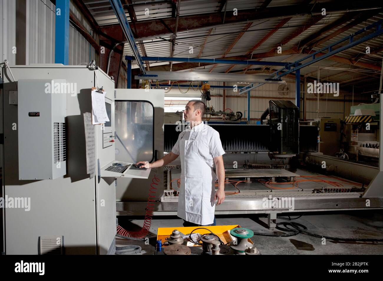 Industrial factory worker operating machinery Stock Photo - Alamy