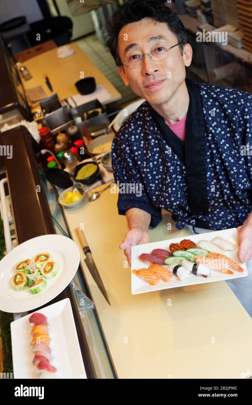 Portrait of a happy chef with Japanese sushi in restaurant Stock Photo ...