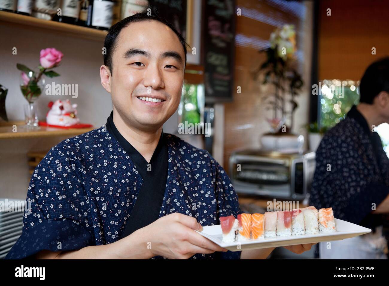 Portrait of a happy chef with sushi in restaurant Stock Photo - Alamy