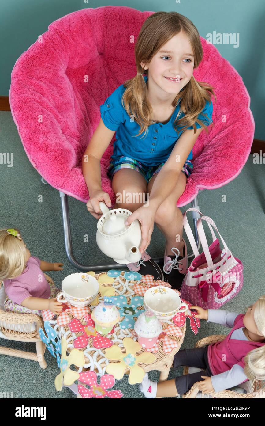 Girl pretending to have tea party with her dolls Stock Photo - Alamy
