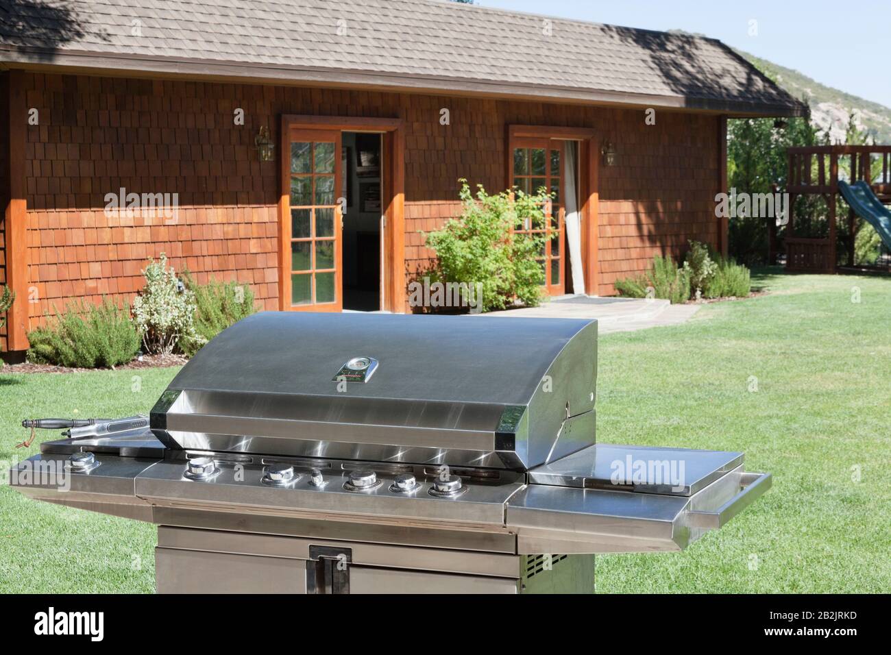 Stainless steel barbecue grill in front of house at lawn Stock Photo ...