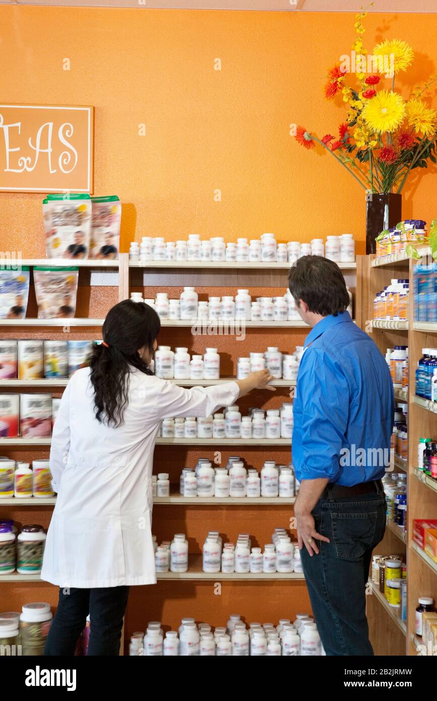 Back view of a female employee helping customer in drugstore Stock ...