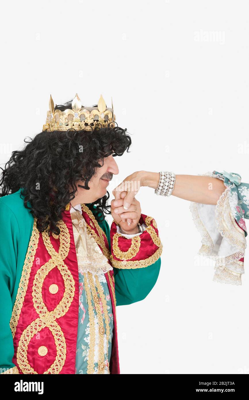 Senior king kissing the hand of queen over gray background Stock Photo ...