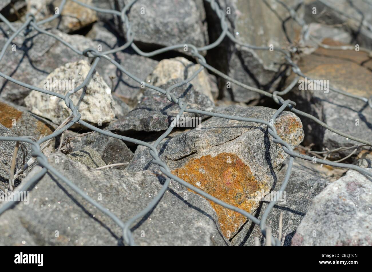 Gabion. Stone fence in a metal mesh. Crushed stone packed in wire mesh ...