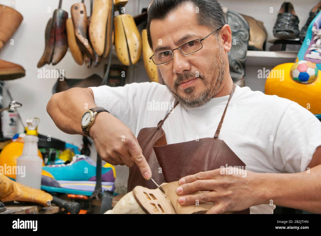 Portrait of a skilled shoemaker cutting shoe sole Stock Photo - Alamy
