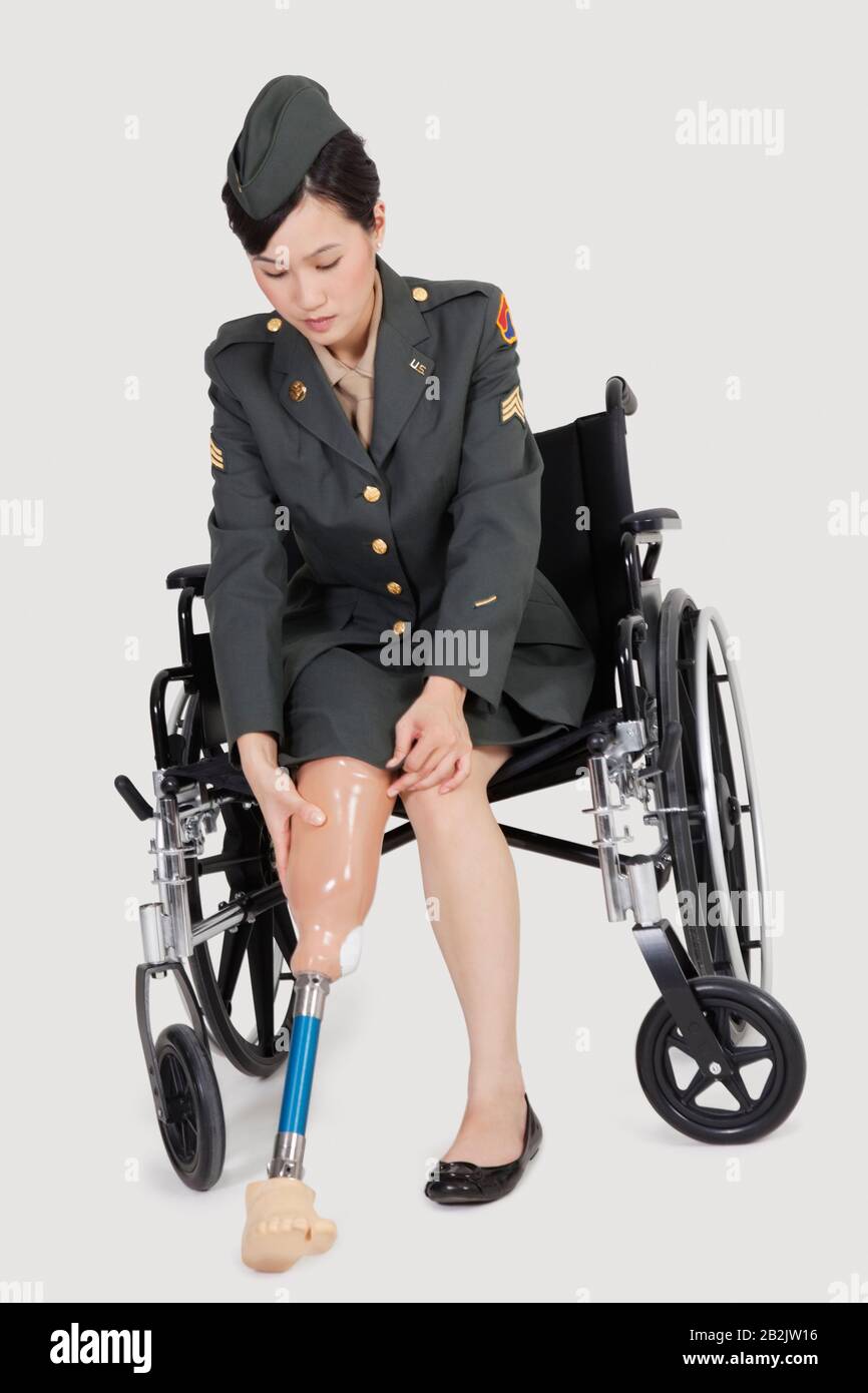Female US military officer in wheelchair fitting prosthesis foot over ...