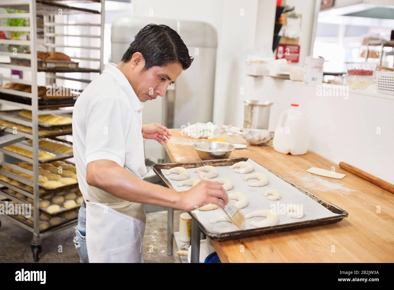 Side view of a young male baker making dough in bakery Stock Photo - Alamy