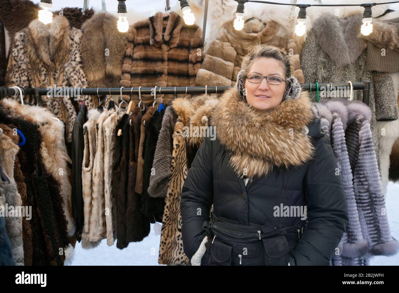 Portrait of a mature woman standing in front of fur stall Stock Photo ...