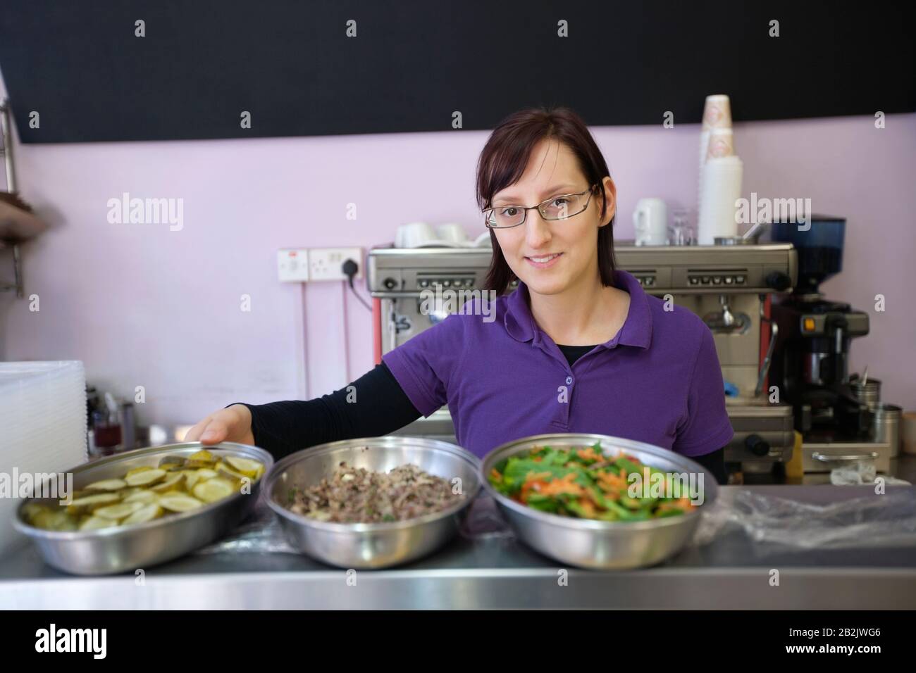 Portrait of a young female employee working in cafe Stock Photo - Alamy