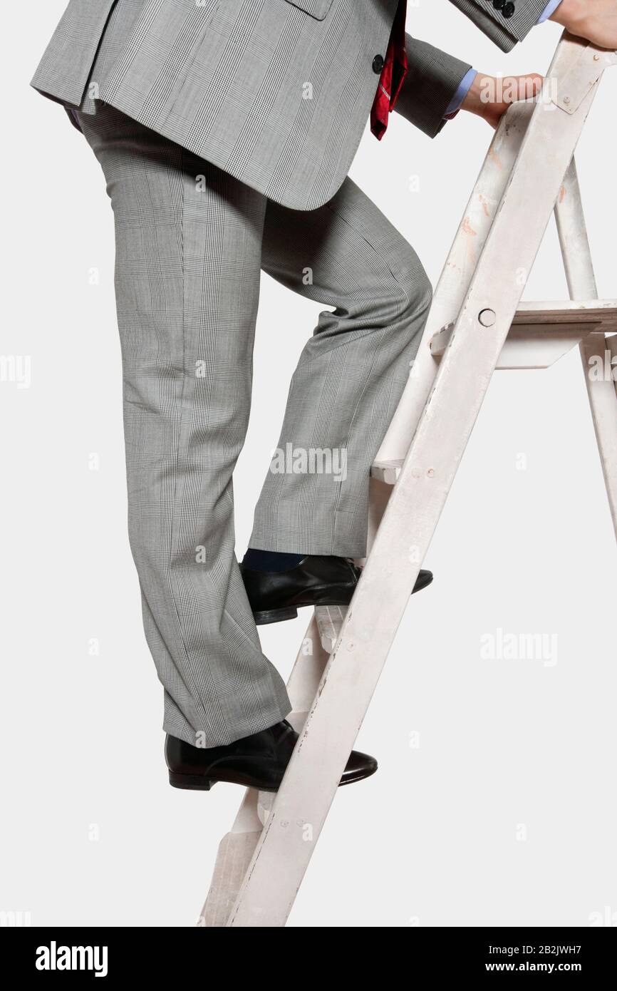 Low section view of a businessman climbing up a ladder Stock Photo - Alamy