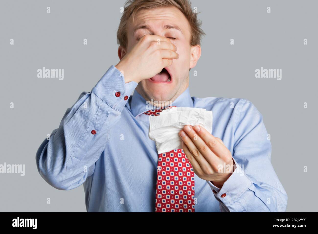 Front view of young man sneezing over colored background Stock Photo ...
