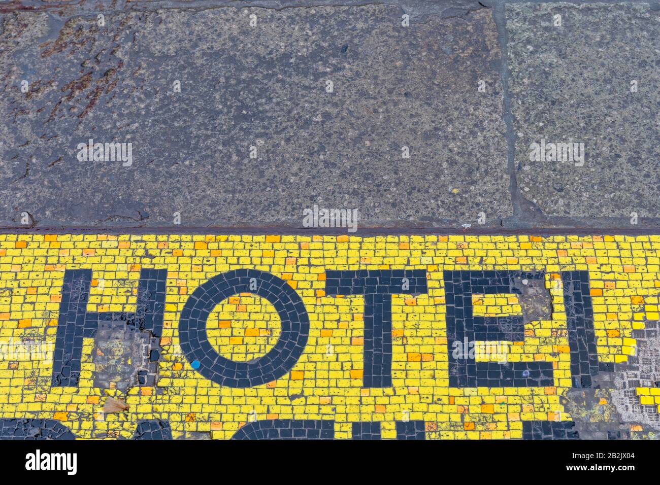 Damaged Hotel Sign Mosaic Tiles at Pavement Stock Photo - Alamy