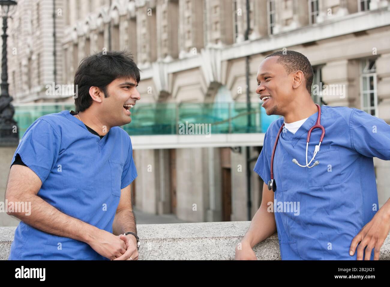Multi ethnic doctors laughing over something with building in ...