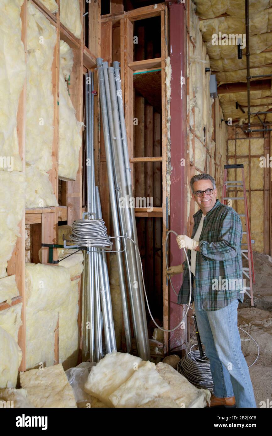 Worker with iron cable standing at construction site Stock Photo - Alamy