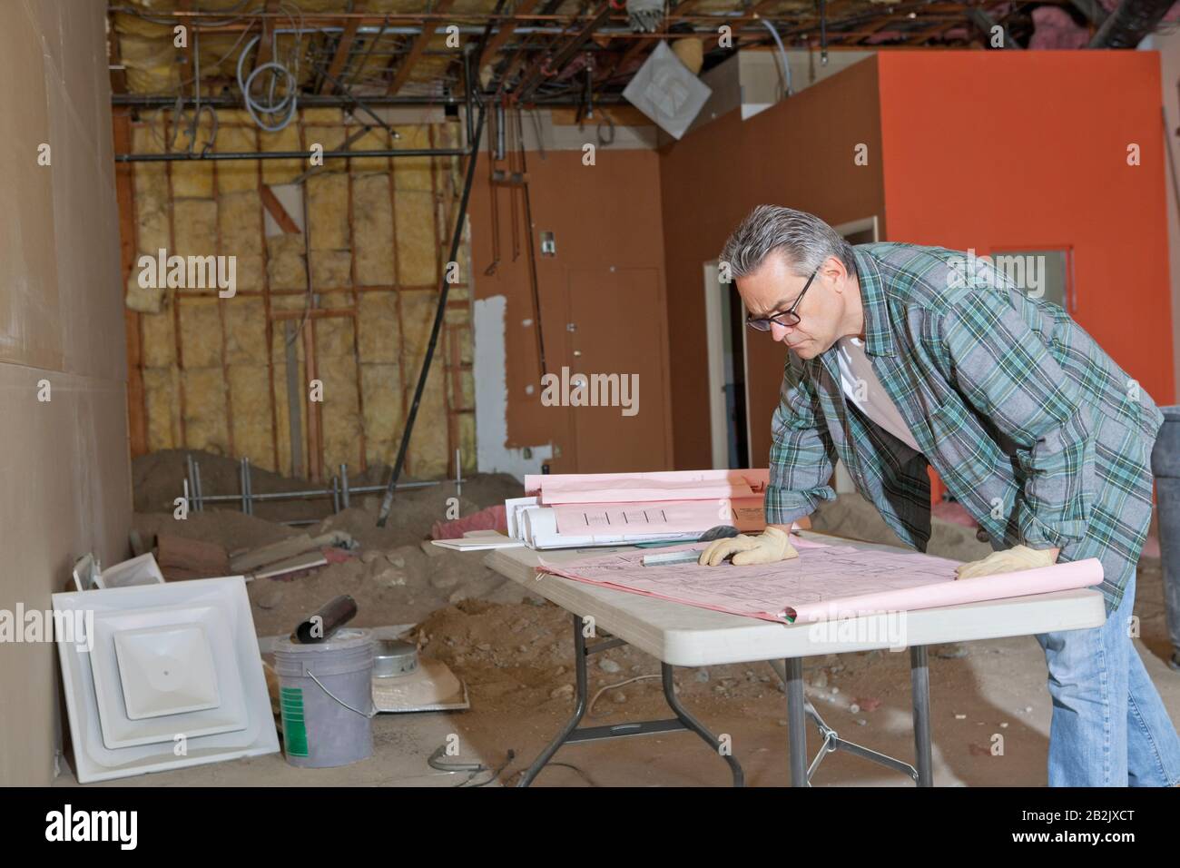 Architect looking at building plans at construction area Stock Photo ...