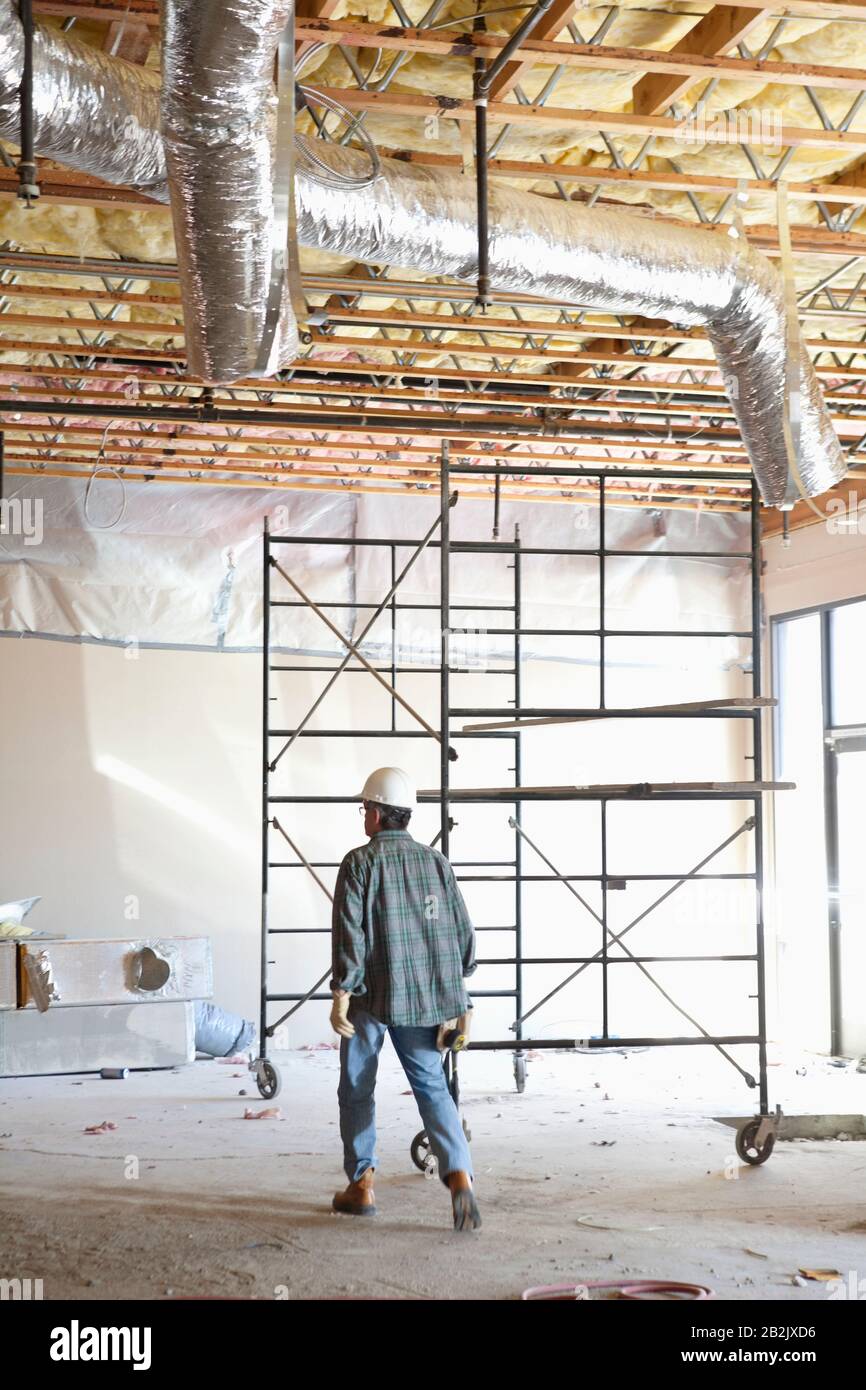 Back view of contractor walking at construction site Stock Photo - Alamy