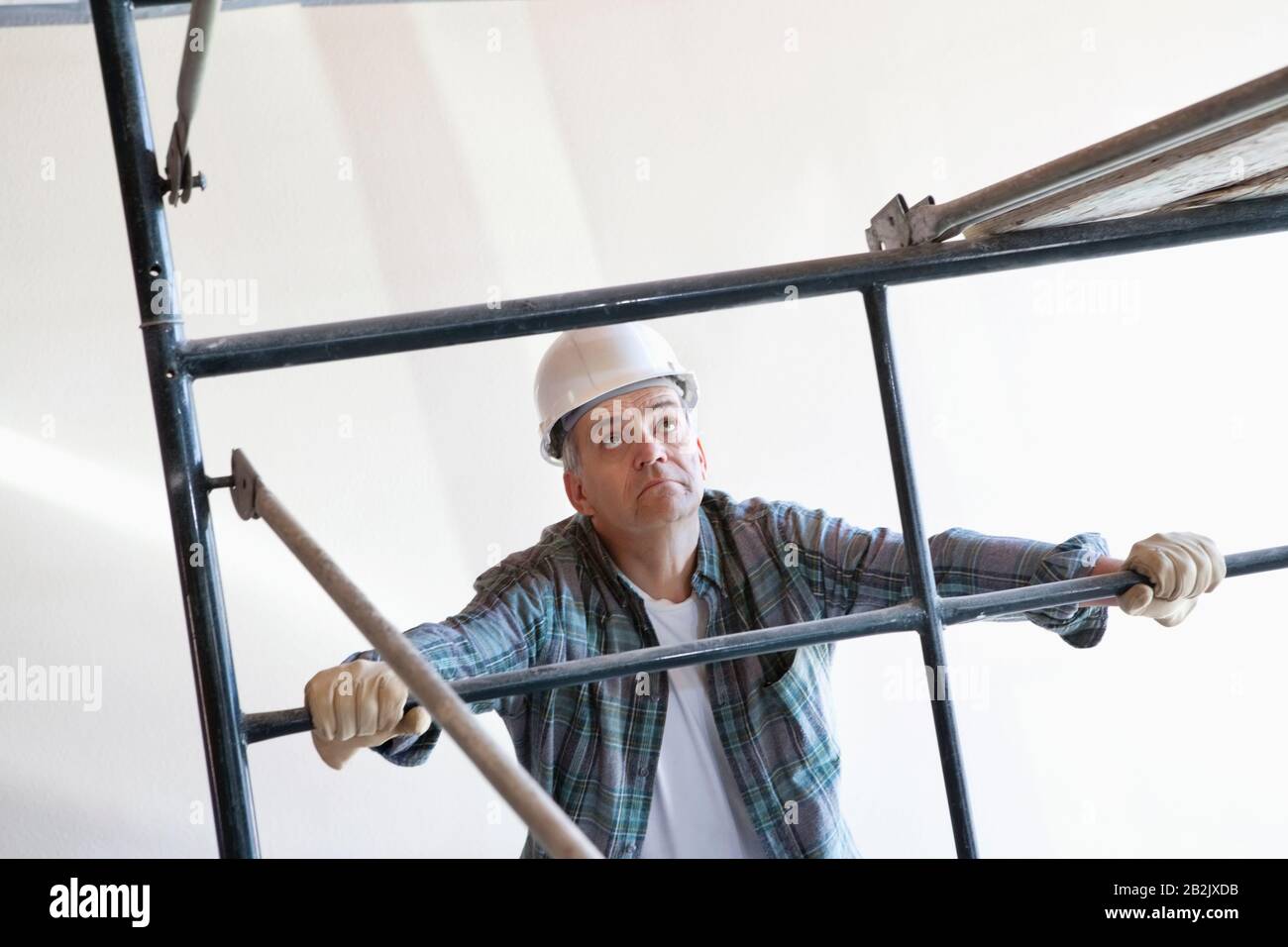 Construction worker standing near scaffolding while looking up Stock ...