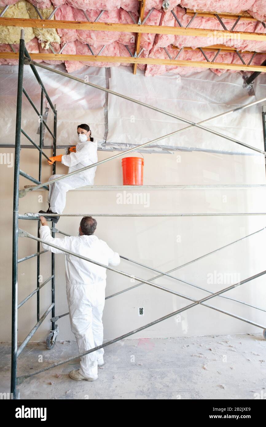 Two construction workers painting a room Stock Photo - Alamy