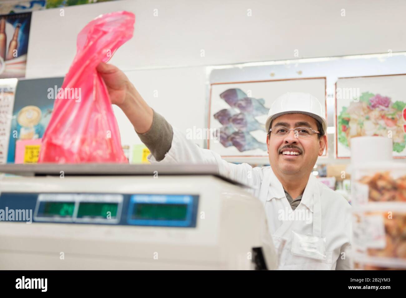 Portrait of butcher giving away meat in plastic bag Stock Photo - Alamy