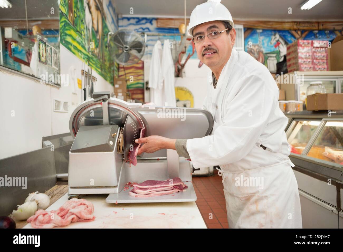 Butcher looking away while meat coming out of fly wheel slicer Stock ...