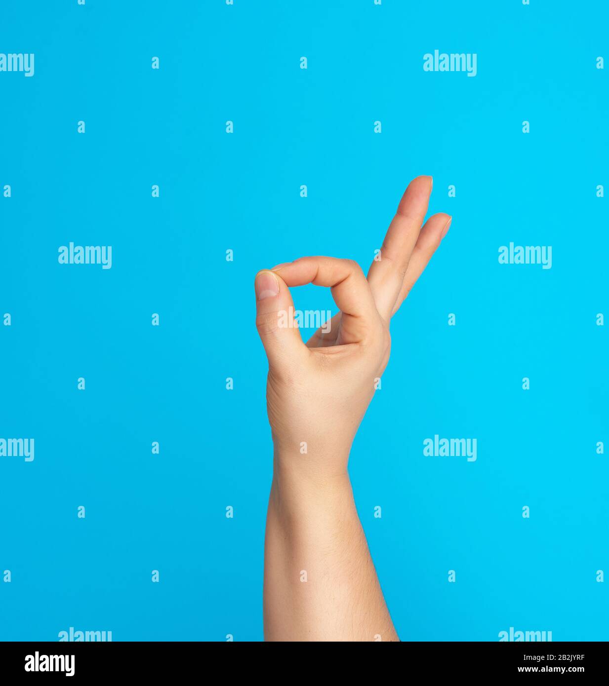 hand shows ok symbol on a blue background, positive emotion, close up ...