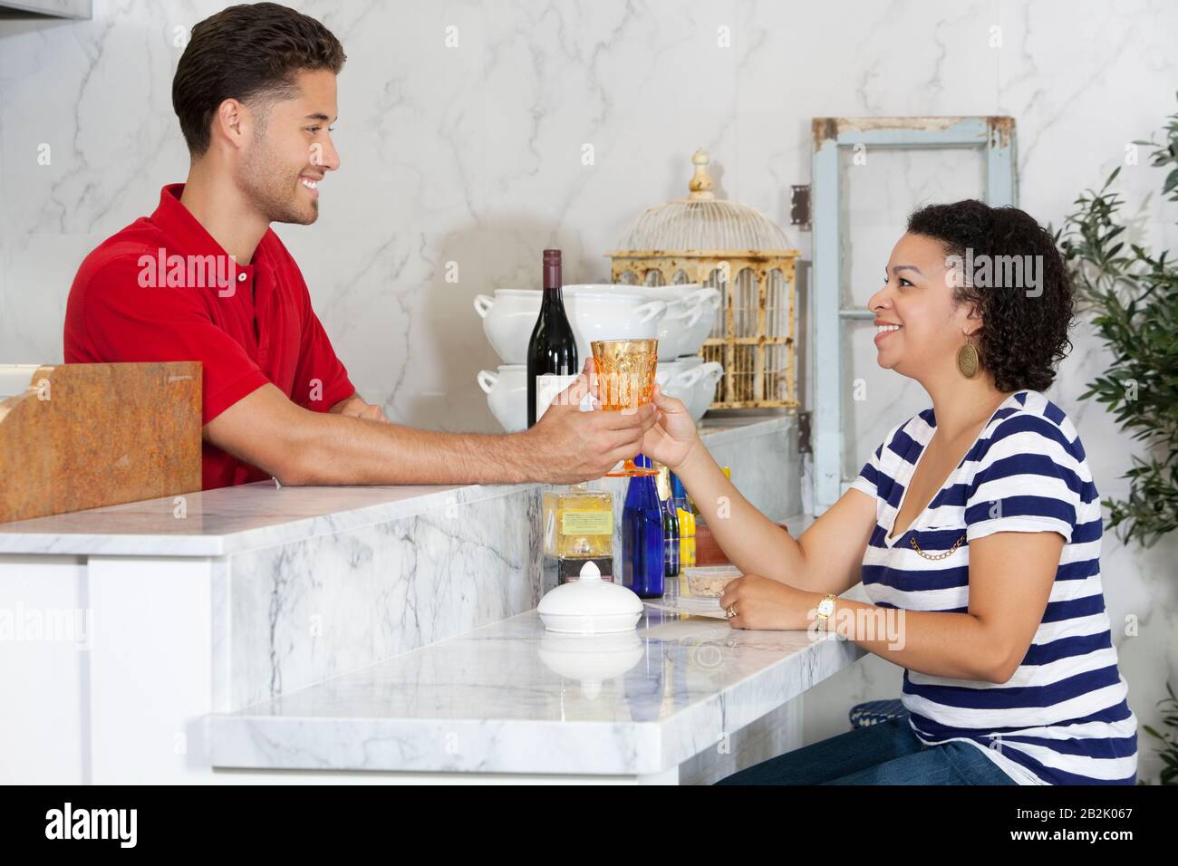 Woman handing over empty glass to male waiter at counter Stock Photo ...