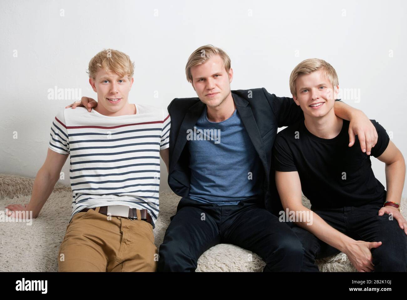 Portrait of happy male friends sitting together Stock Photo - Alamy