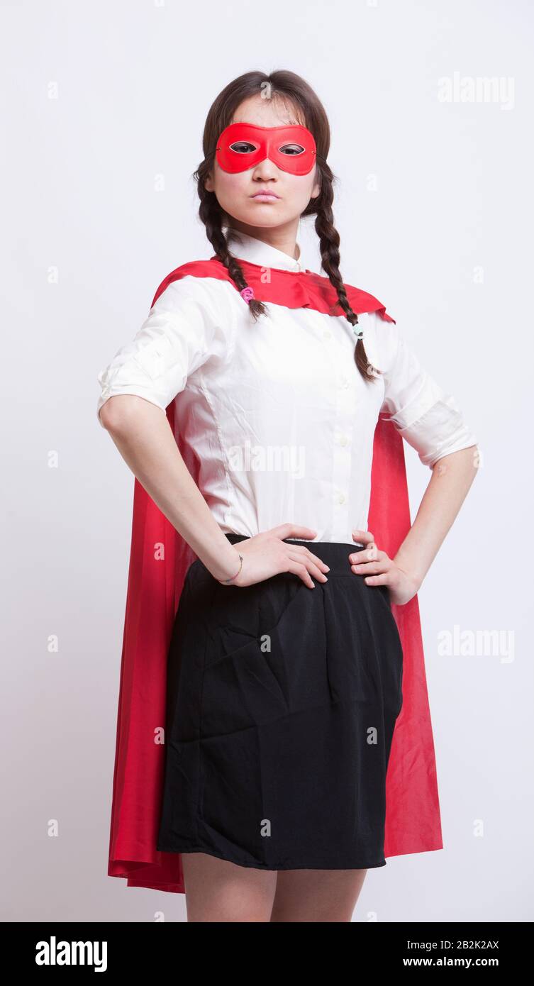 Portrait of young Asian woman in superhero costume with hands on hips ...
