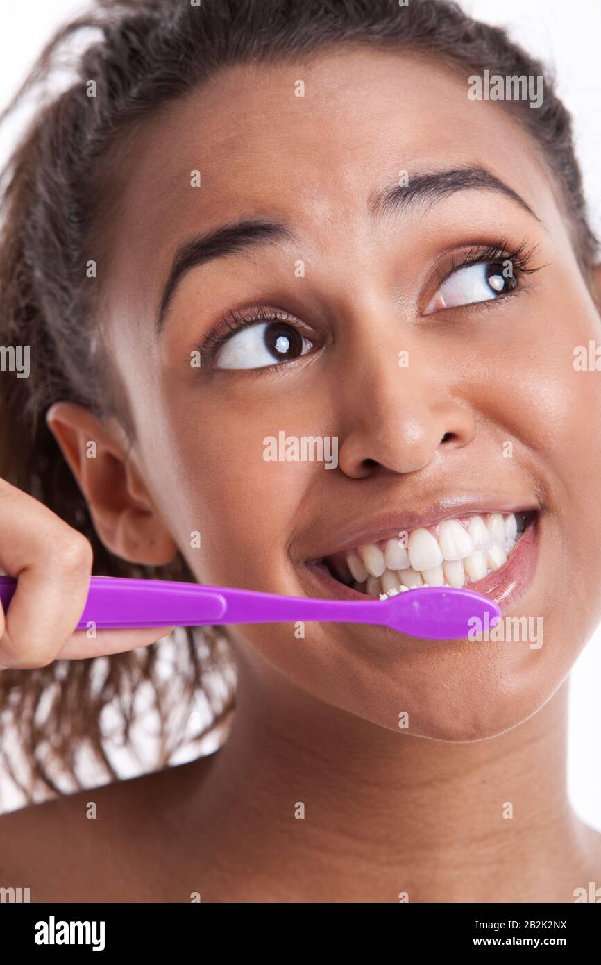 Young Mixed Race woman brushing teeth against white background Stock ...