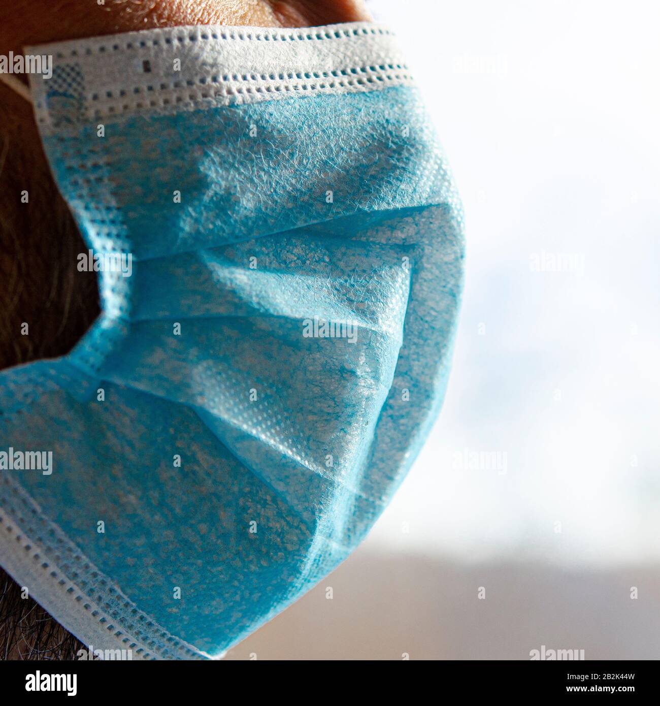 The face of a man in a blue protective medical mask Stock Photo - Alamy