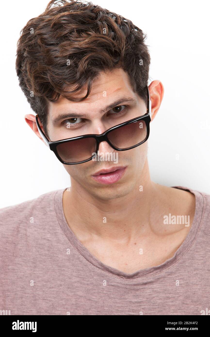 Portrait of confident young man staring against white background Stock ...