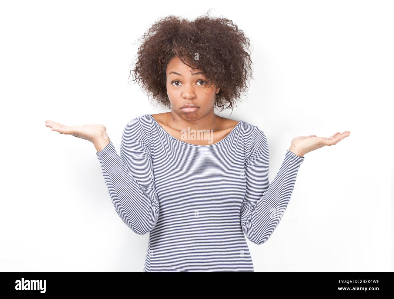 Portrait of confused African American young woman shrugging against ...