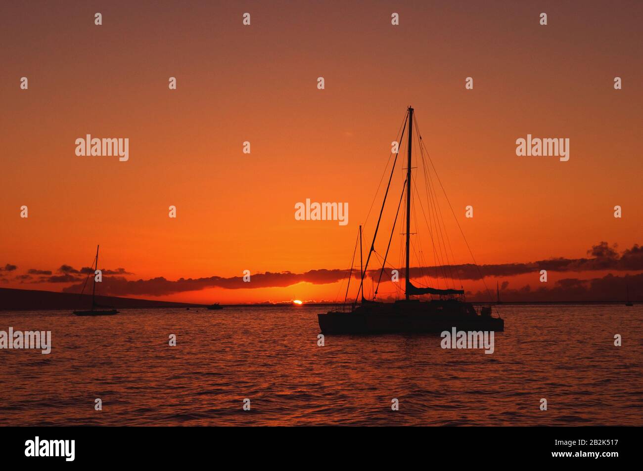 Silhouetted sailing boat heading into the sunset Stock Photo - Alamy