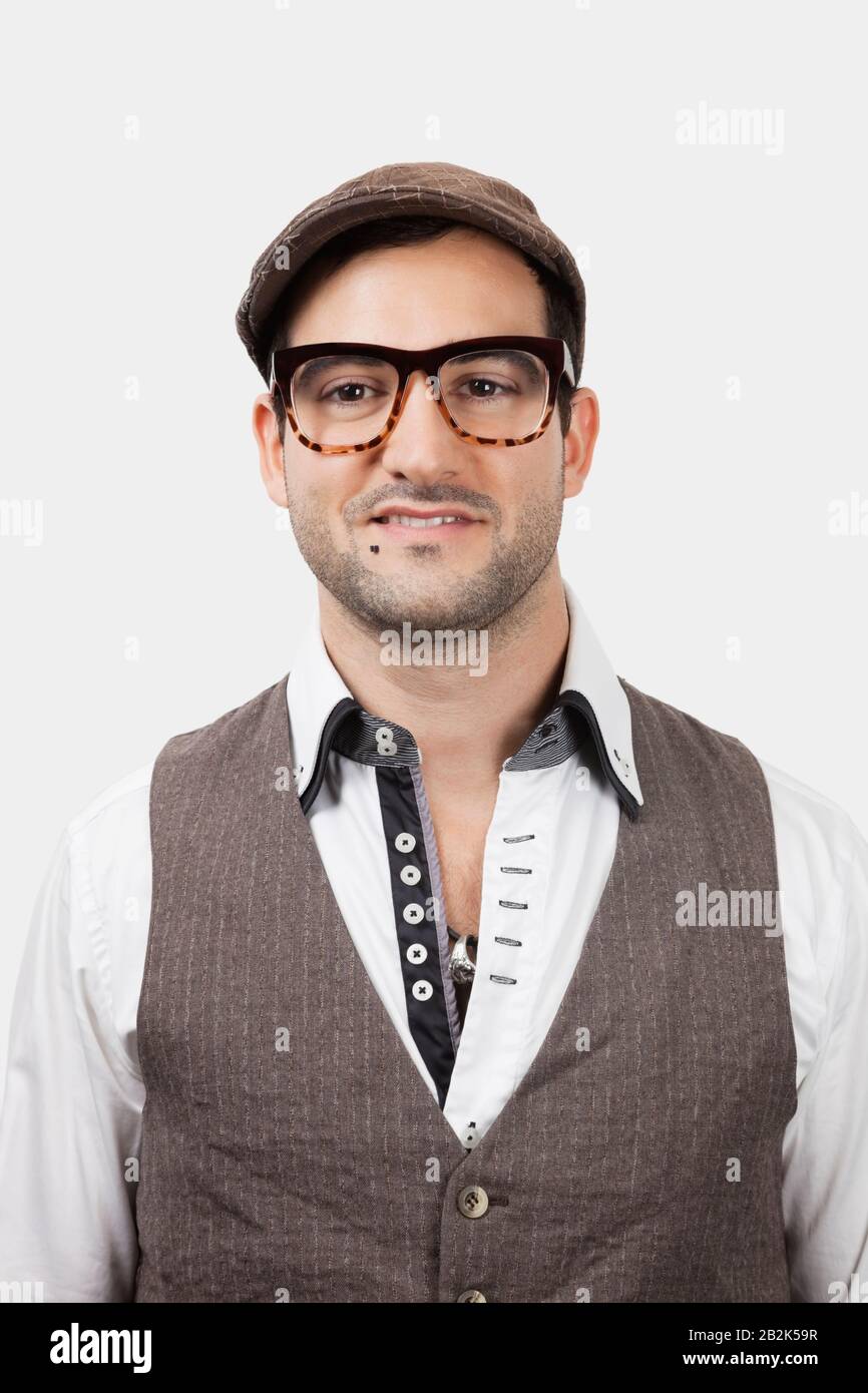 Portrait of young Caucasian man in flat cap against white background ...