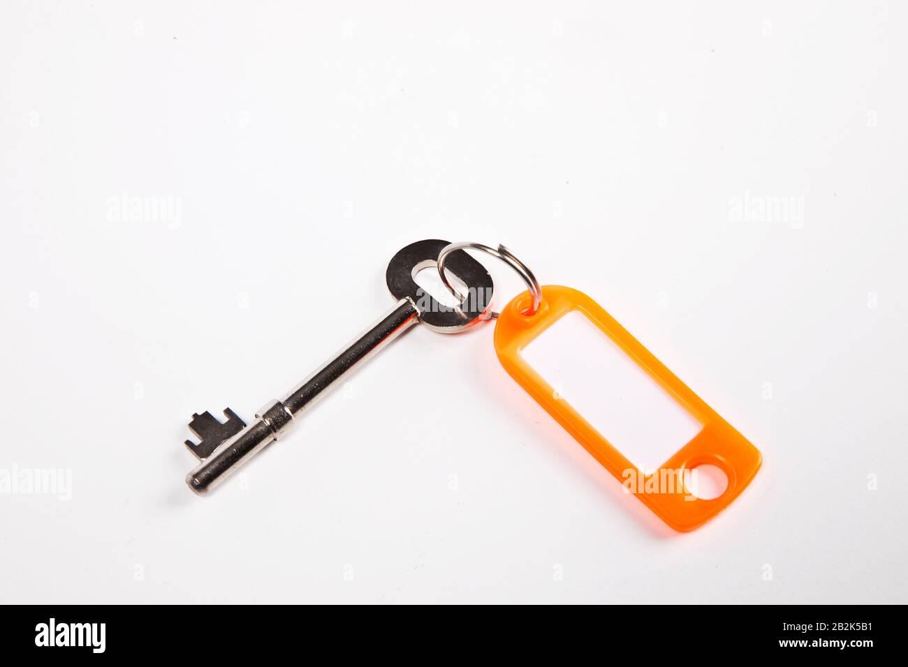 Key with orange key ring tag on white background Stock Photo - Alamy