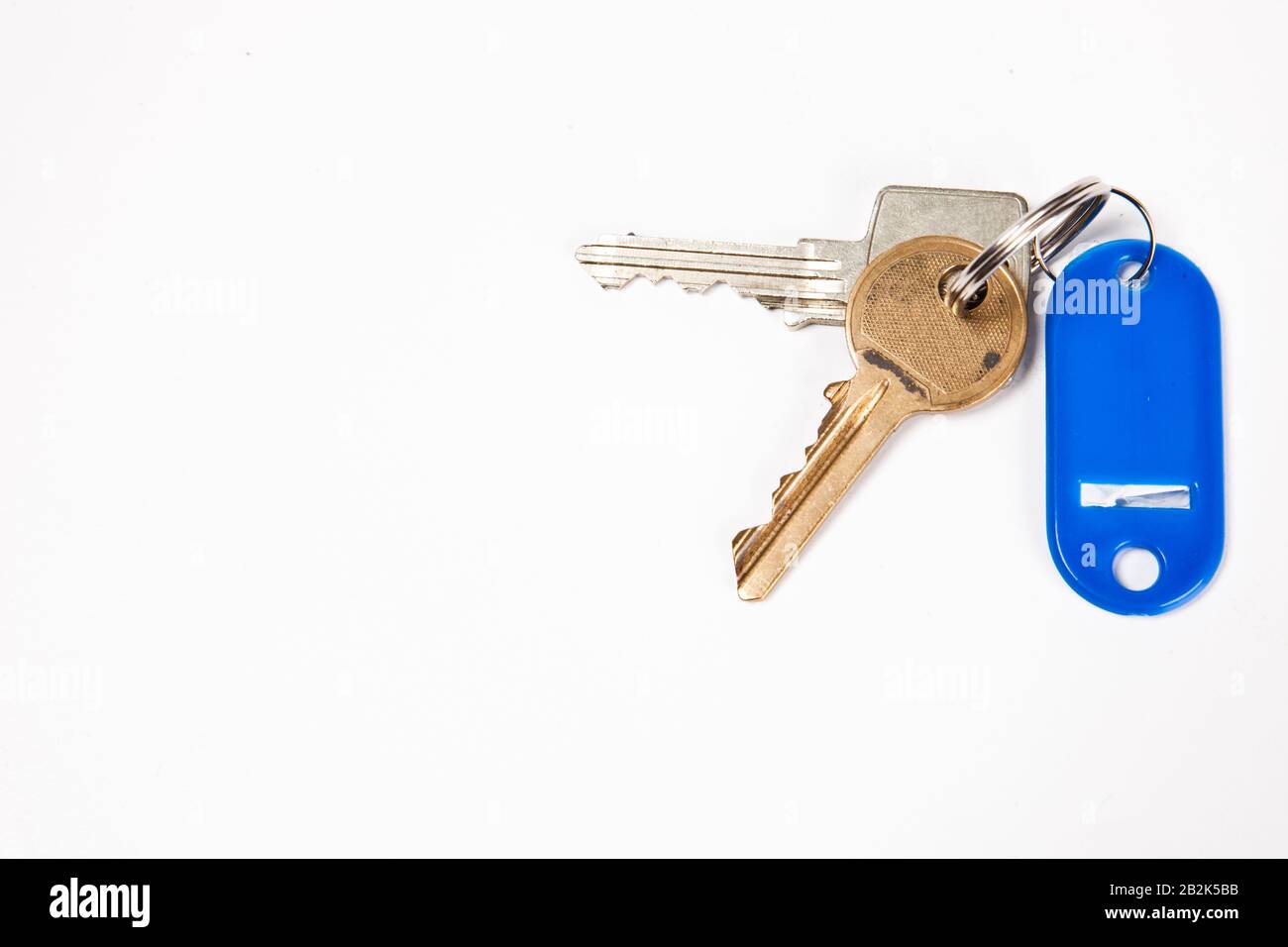 Keys with blue key ring tag on white background Stock Photo - Alamy