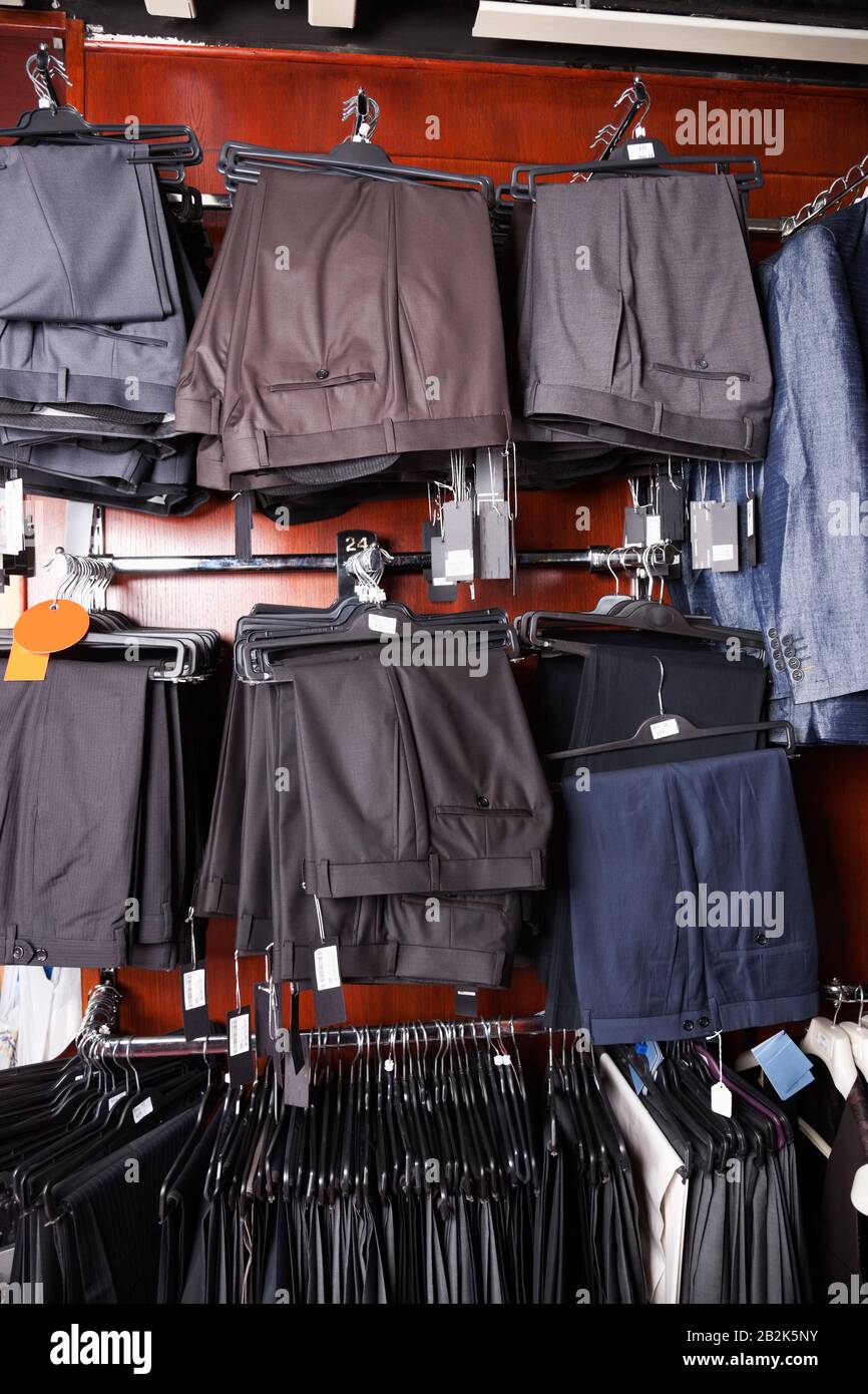 Variety of formal pants hanging on hanger at store Stock Photo - Alamy