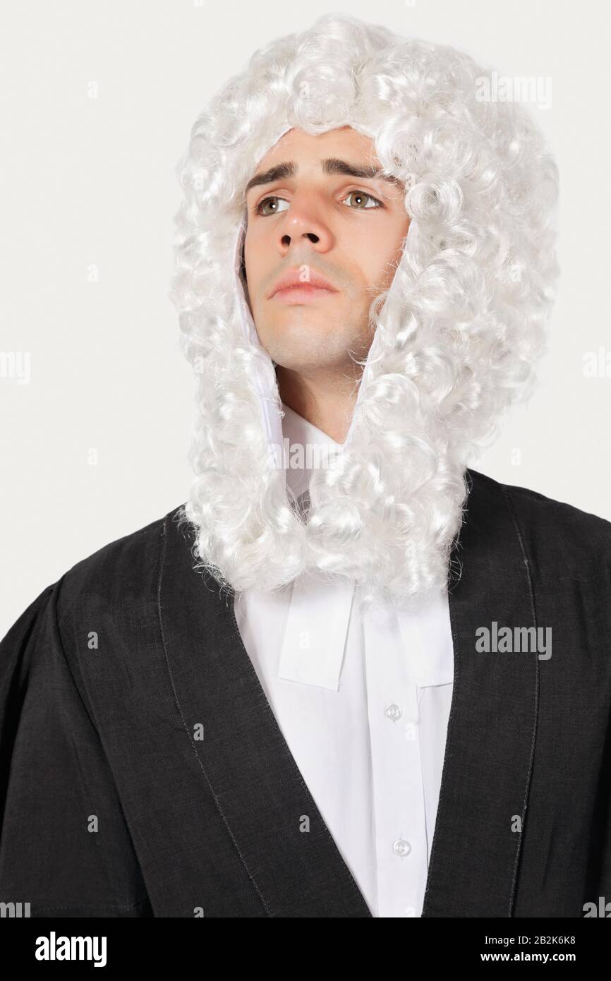 Young man dressed as judge looking away over gray background Stock ...