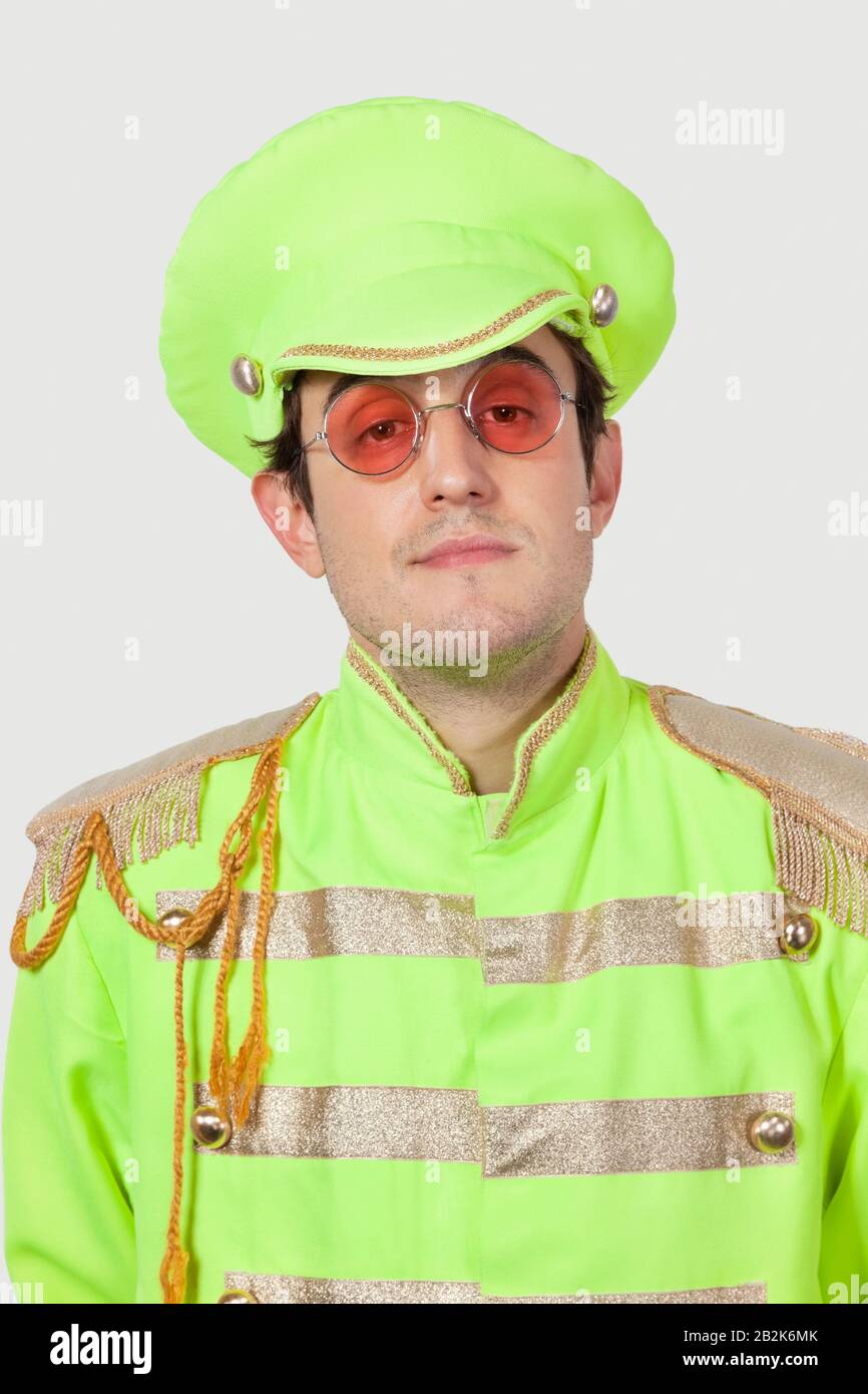 Portrait of young male marching band member in green colored costume ...