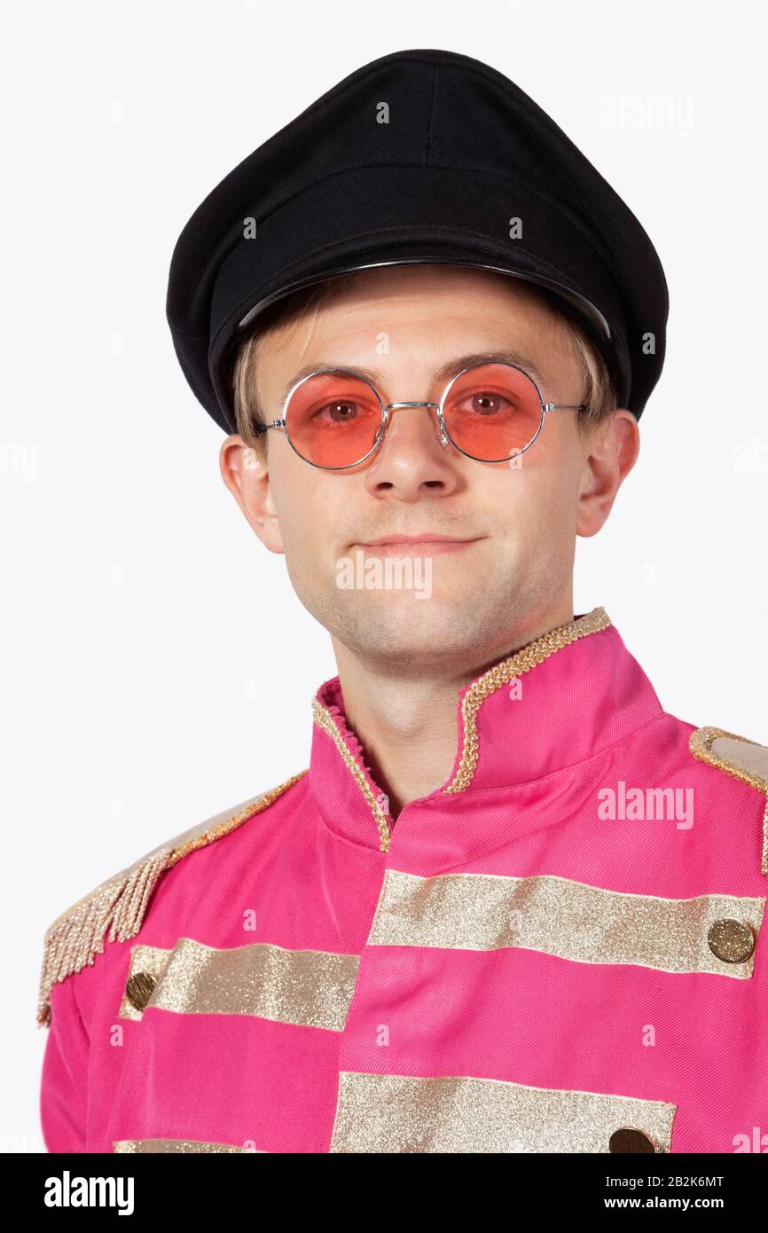Portrait of young male marching band member in pink colored costume ...