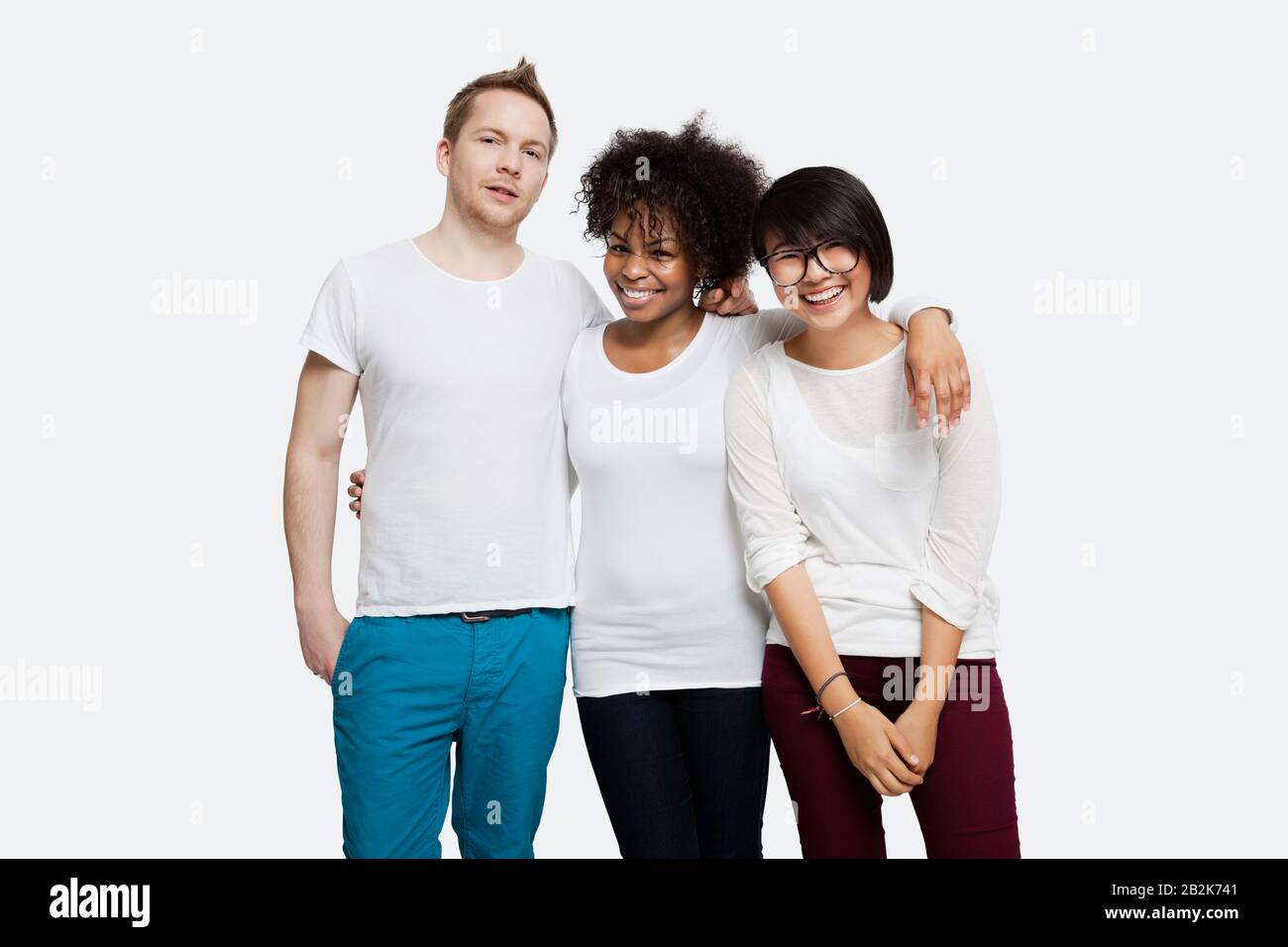 Portrait of happy multi-ethnic friends in casuals with arm around each ...