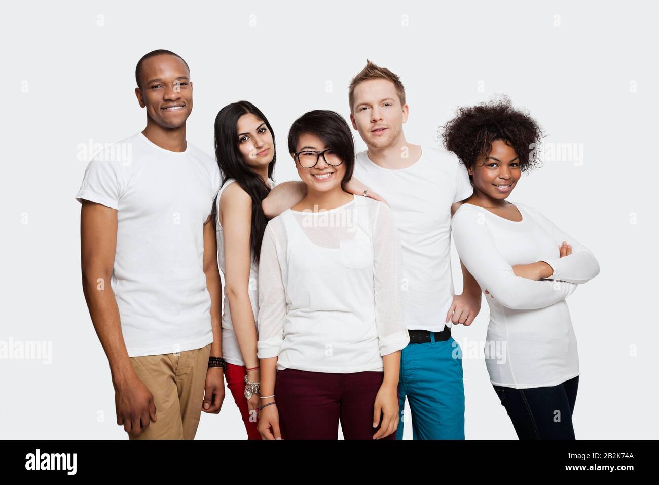 Portrait of multi-ethnic friends in casuals smiling together over white ...
