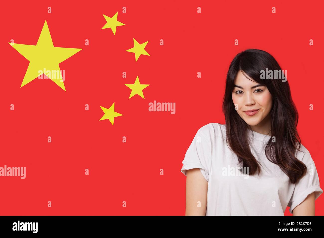 Portrait of smiling mixed race young woman against Chinese flag Stock ...