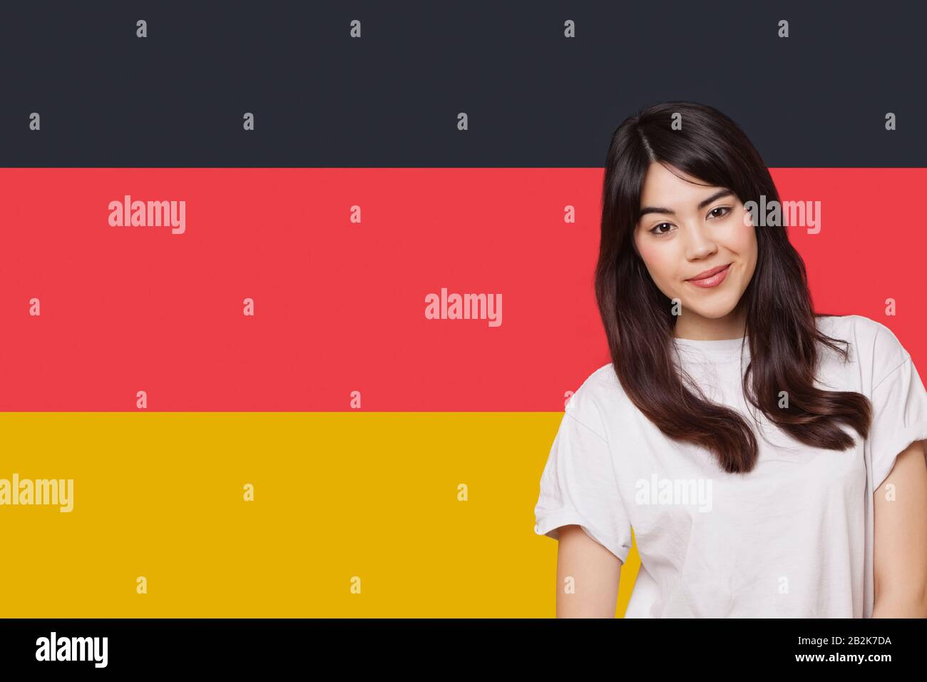 Portrait of smiling mixed race young woman against German flag Stock ...