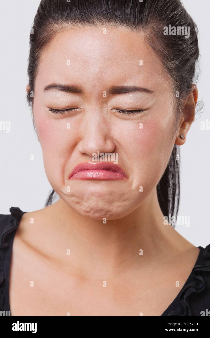 Close-up of young Chinese woman crying over white background Stock ...